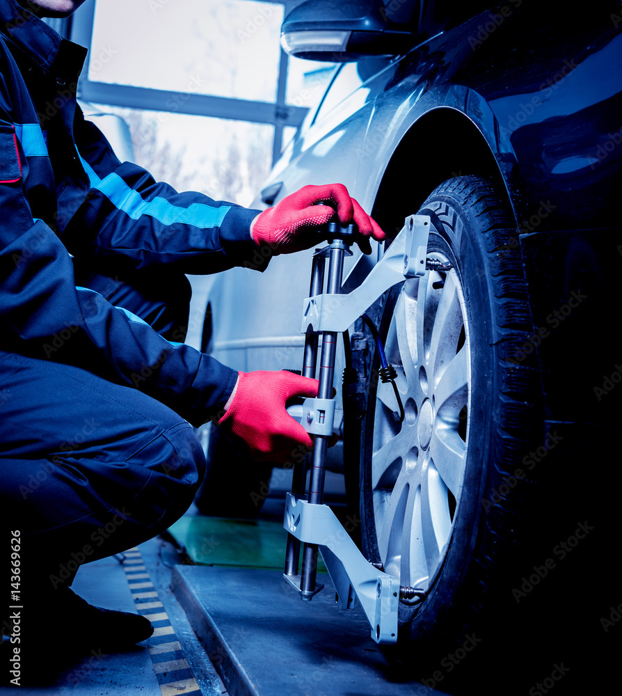 Car mechanic installing sensor during suspension adjustment. Stock ...