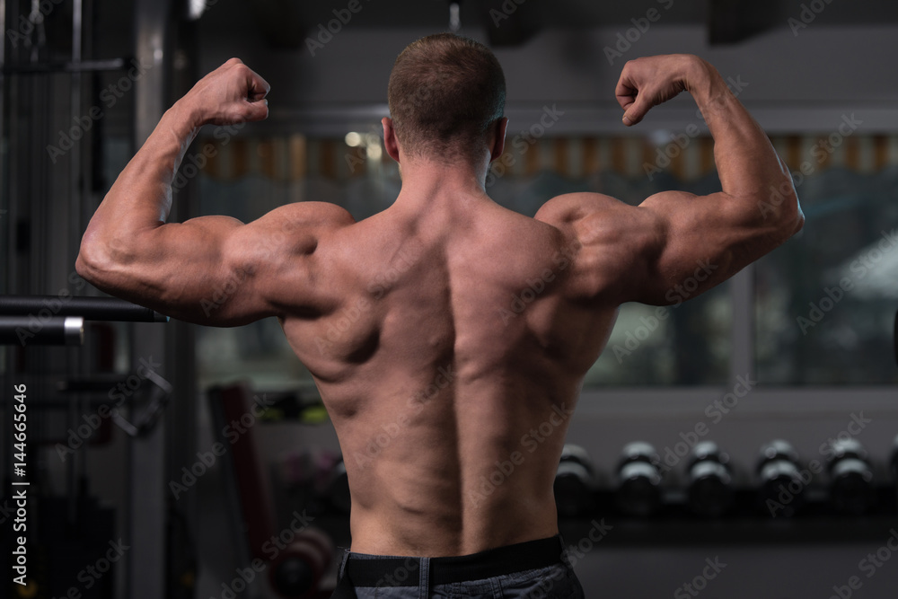Foto de Stock Muscular Man Flexing Back Muscles Pose | Adobe Stock