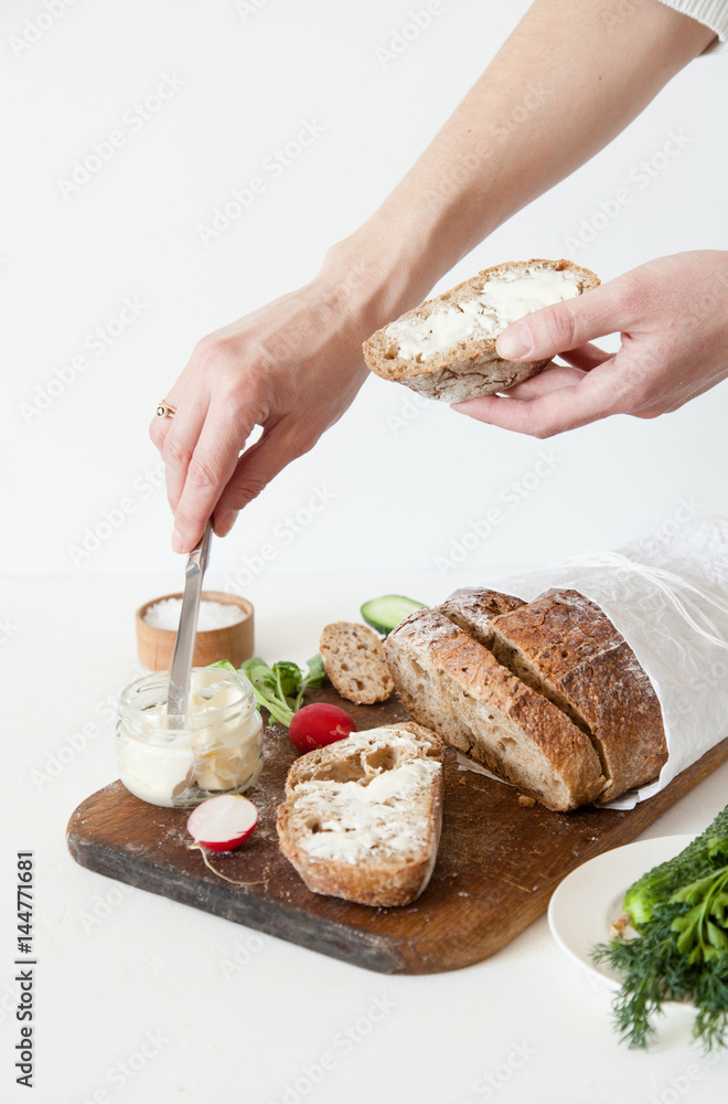 Bread with salt, butter, cucumber and radishes lie on a white ...