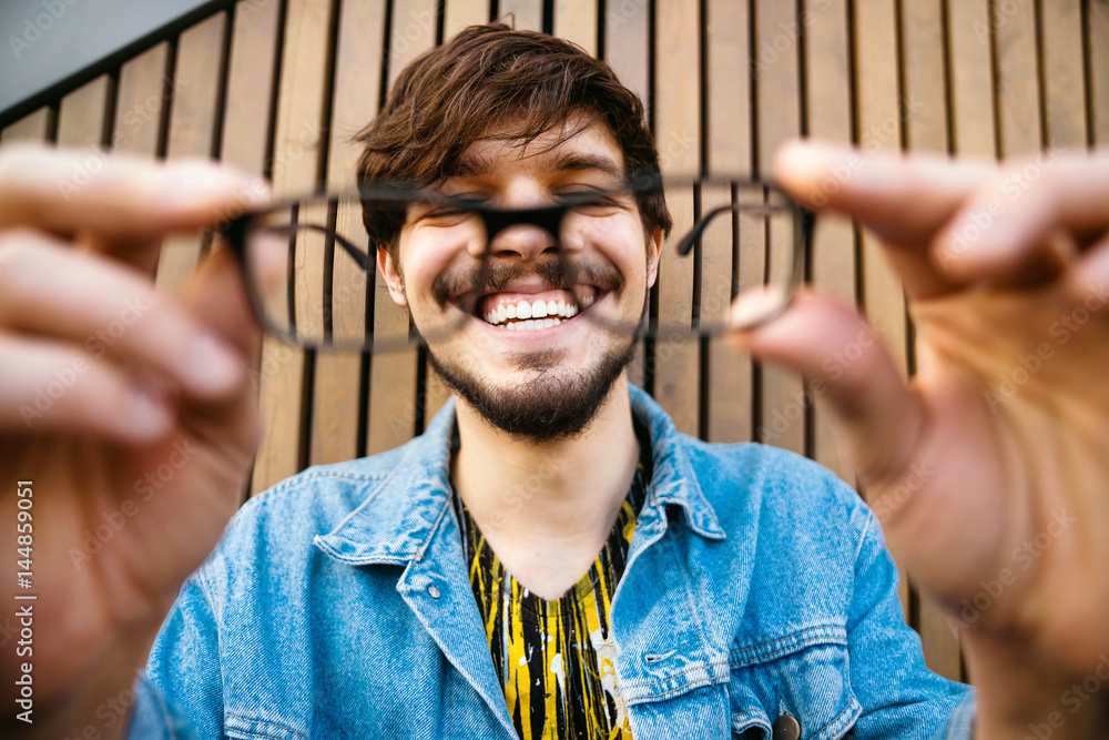 Funny smiling guy with glasses for sight. He holds glasses in his hands ...