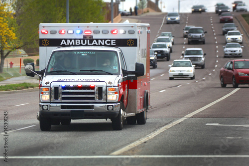 Ambulance with lights on driving down road - Buy this stock photo and ...