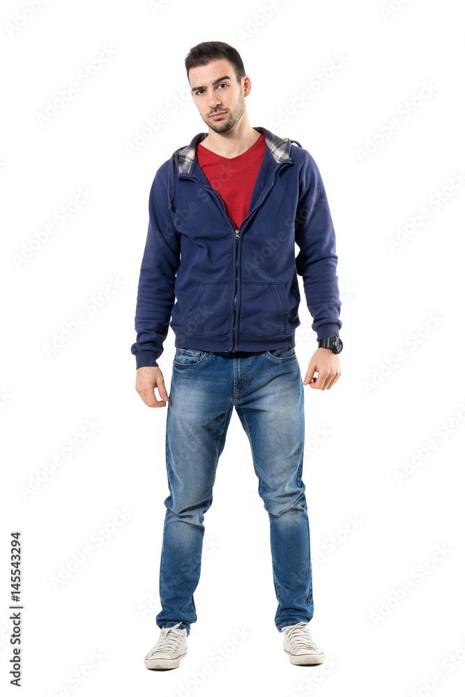 Tense young casual man in blue hooded sweatshirt looking at camera ...