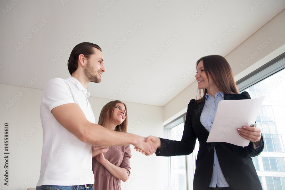 Real estate agent showing apartment to young man and woman, cheerful ...