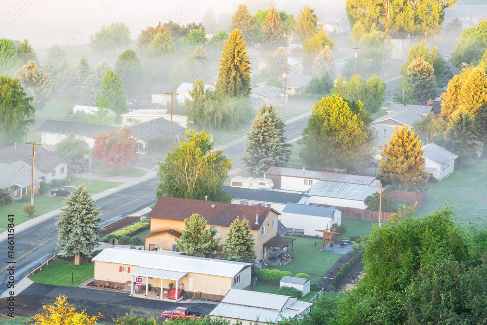 Misty spring landscape with foggy and first ray of early morning light ...