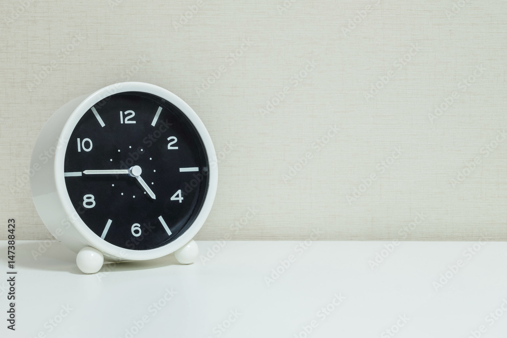 Closeup black and white alarm clock for decorate in a quarter to five o ...