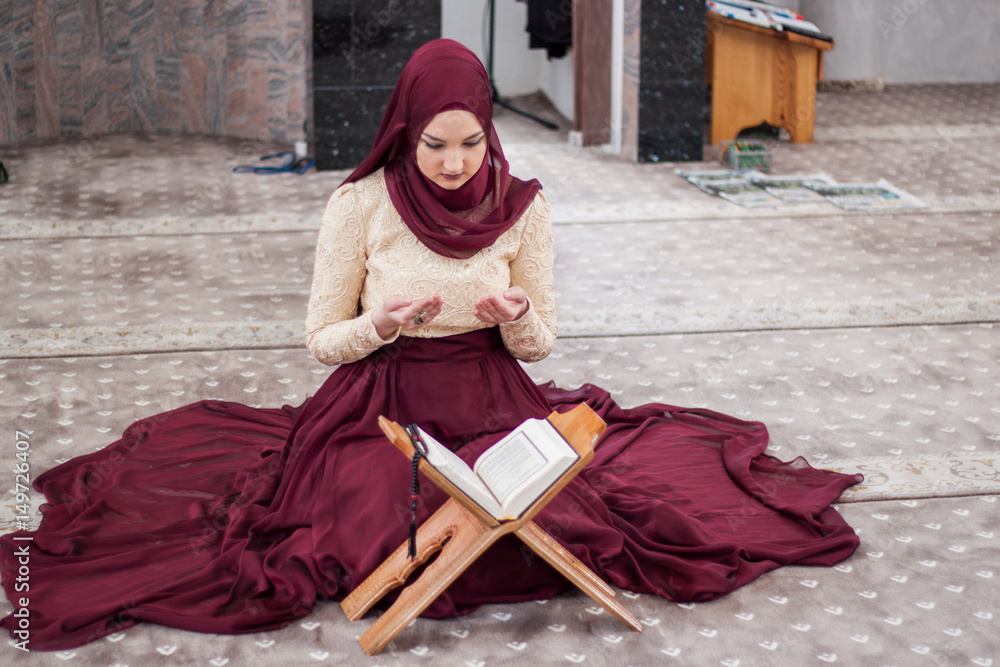 Young and beautiful girl sitting covered in sumptuous dress and teaches ...