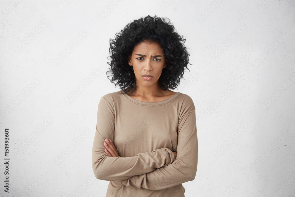 Photo Stock Angry annoyed young housewife keeping arms crossed and ...
