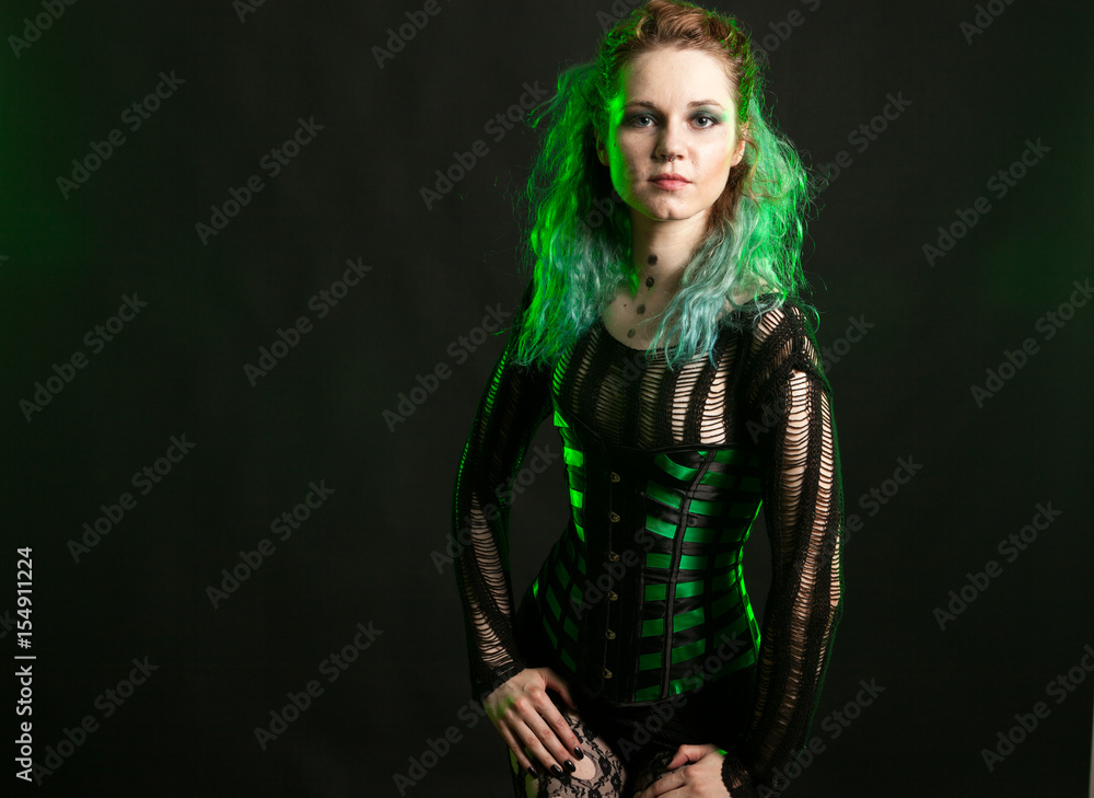 Sexy Woman in cosplay corset posing in studio with a green light from ...