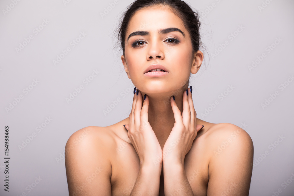 Beautiful face of a young woman with clean fresh skin isolated on gray ...
