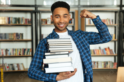 Confident young african male student holding stack of books Stock Photo ... Confident young african male student holding stack of books Stock Photo ...