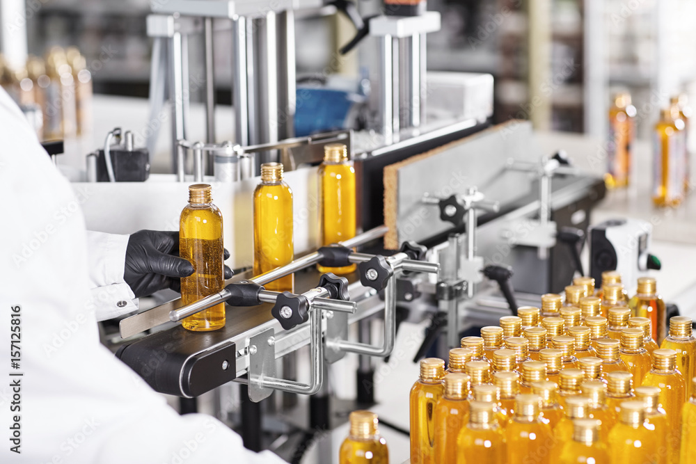 Rear view of unrecognizable factory worker in gown and gloves ...