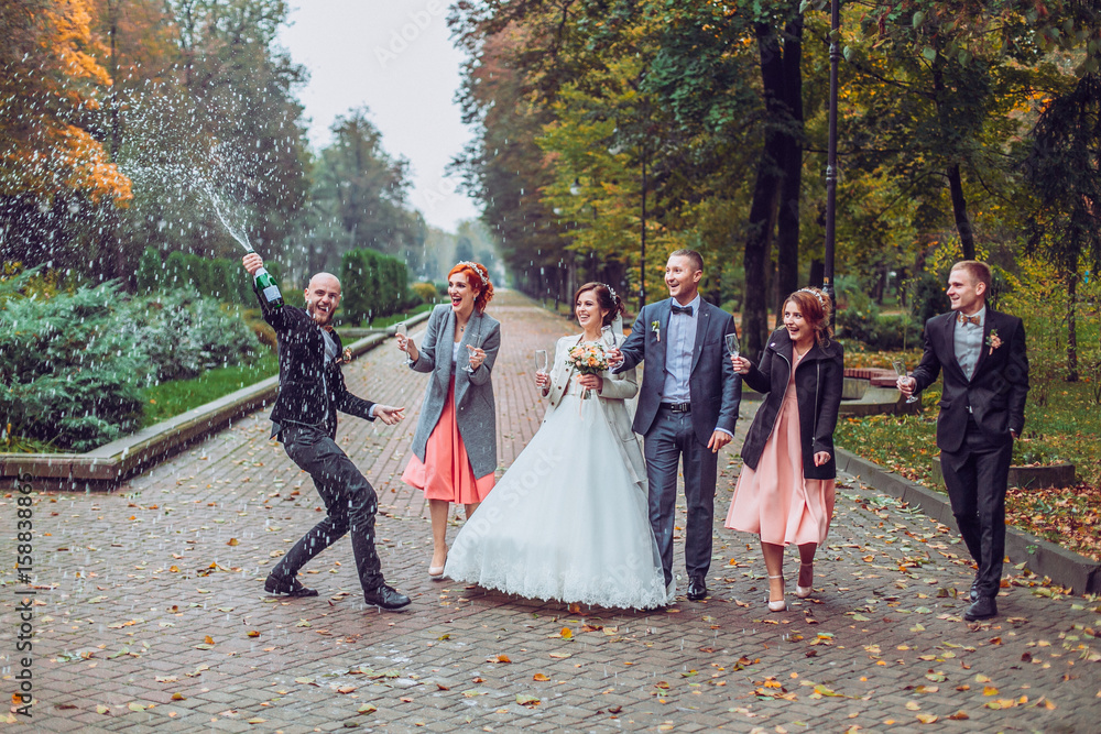 bride and groom with happy groomsmen and bridesmaids having fun and ...