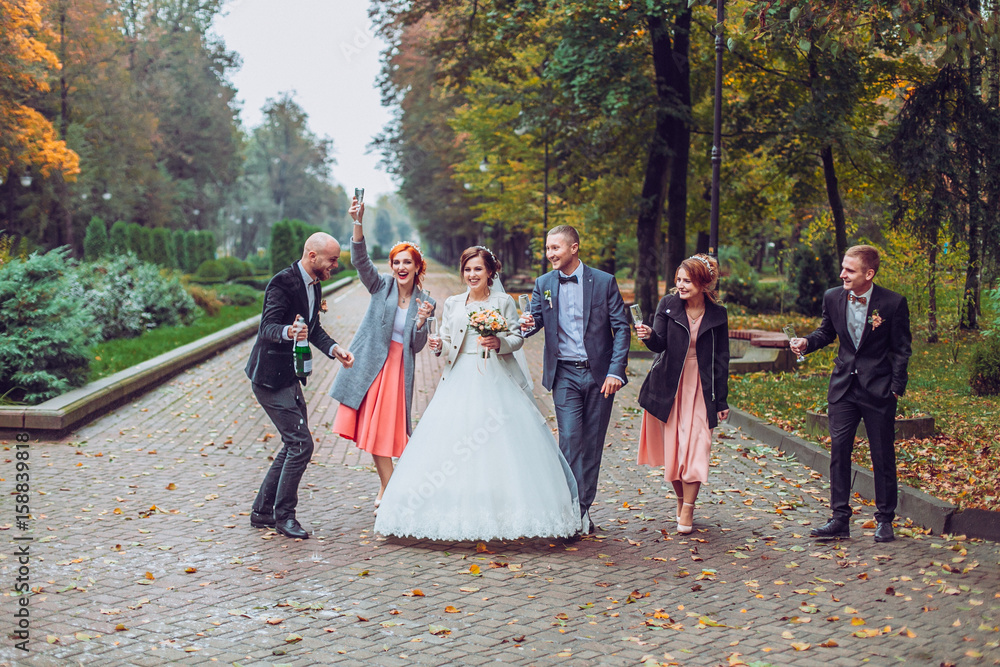 bride and groom with happy groomsmen and bridesmaids having fun and ...