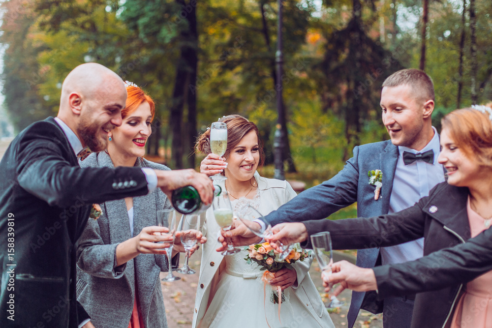 bride and groom with happy groomsmen and bridesmaids having fun and ...