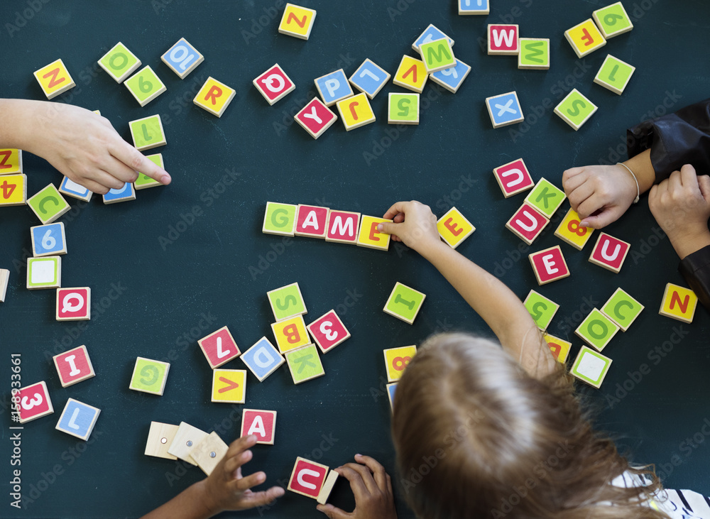 Kindergarten kids playing wooden alphabets letters vocabulary game ...