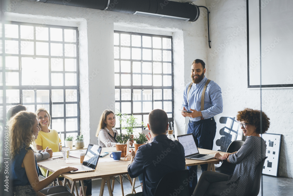 Businessman explaining to colleagues in office meeting Stock Photo ...