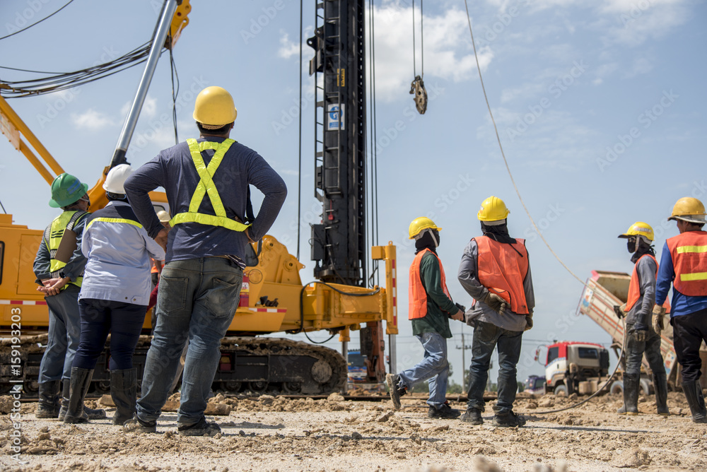 Engineer and foreman looking at heavy machine Assembly concrete pile ...