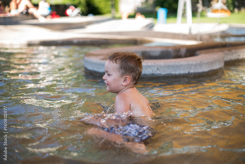 Little boy playing in Swimming Pool For Children With Playground and ...