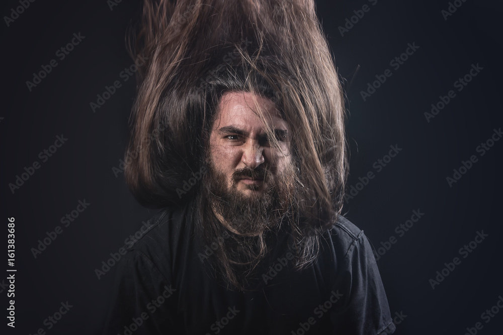 Crazy metalhead long haired man shaking his head and waving his hair ...