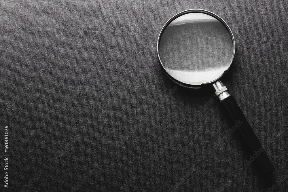 magnifying glass on black texture background. Stock Photo | Adobe Stock