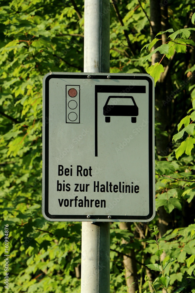 Traffic sign in German language "At red light continue to stop line ...