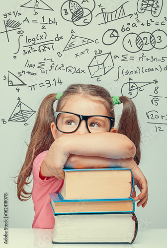 beautiful cute little genius girl with books. Math formulas, problems ...