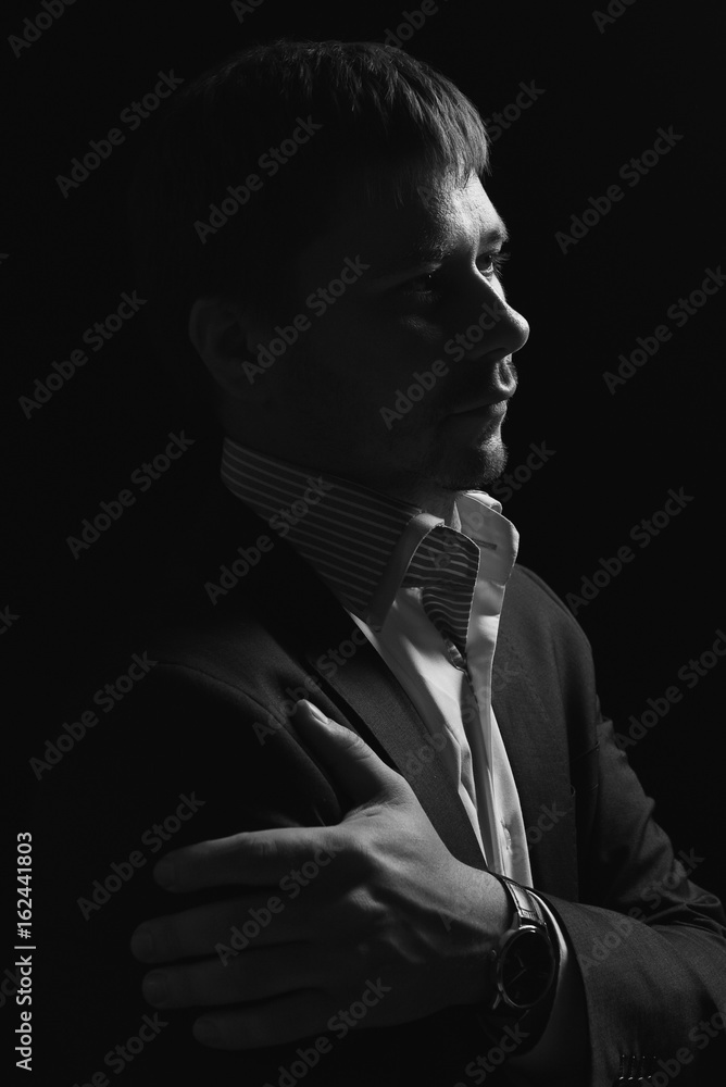 Man low key high-contrast profile portrait in backlight with a serious ...