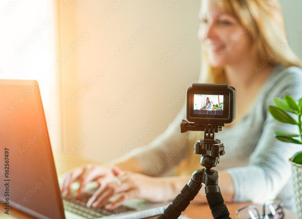 Woman vlogger editing photos and video for her blog with laptop - Girl ...