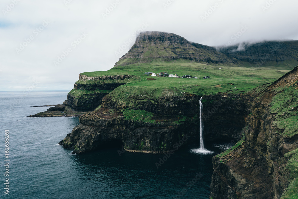 Waterfall dropping into the ocean Stock Photo | Adobe Stock