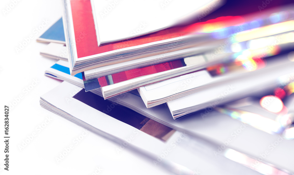 Plano cerrado de revistas y periodicos amontonados sobre fondo blanco ...