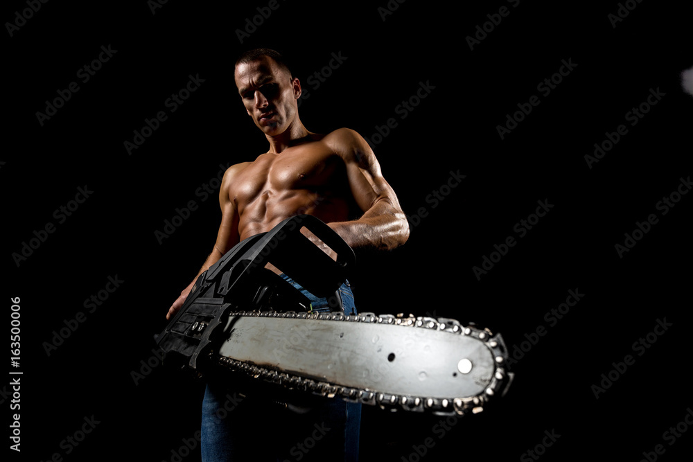 fitness muscular male model with chainsaw Stock Photo | Adobe Stock