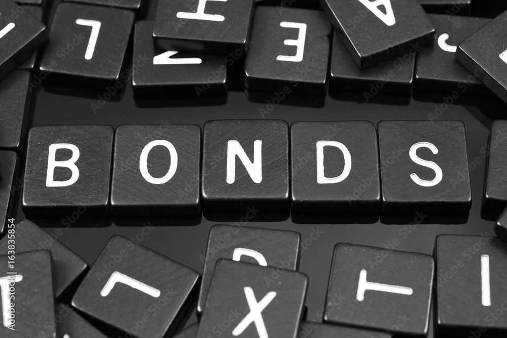 Black letter tiles spelling the word "bonds" on a reflective background ...