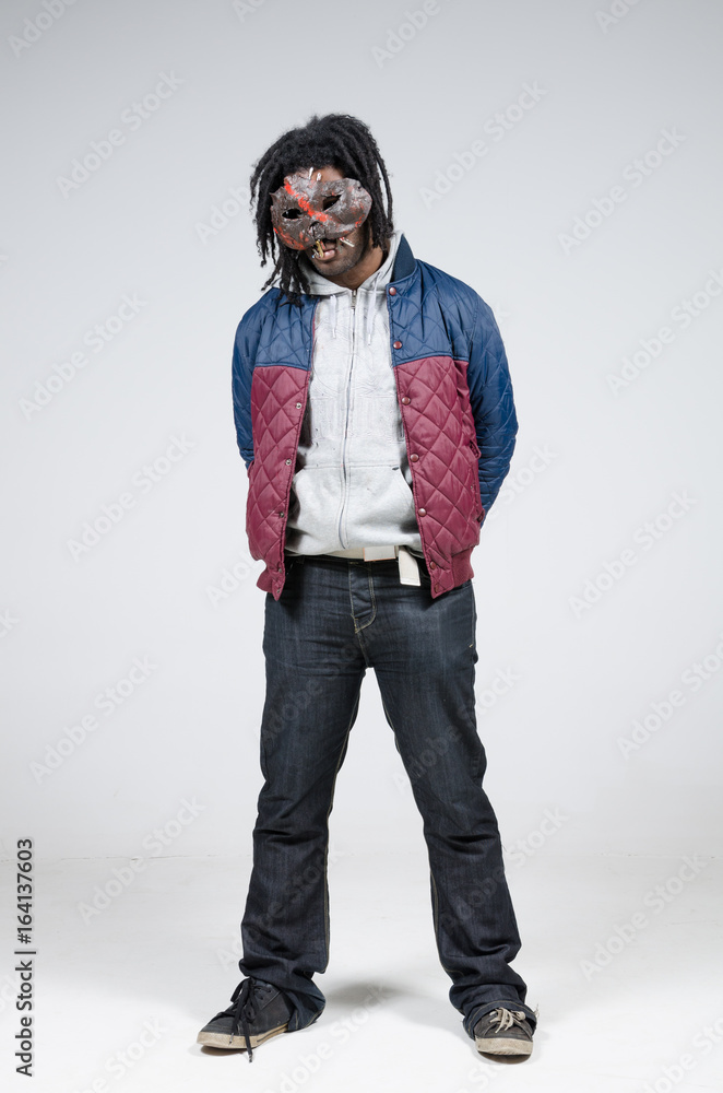 A scary african american male wearing a scary mask photographed against ...