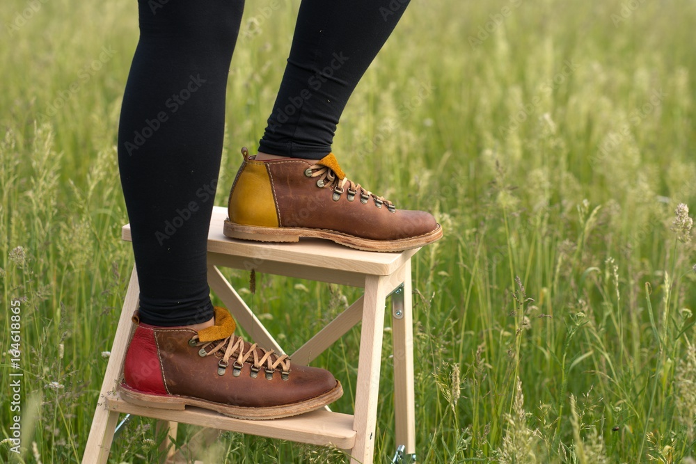 girl in leather boots goes up on the chair Stock Photo | Adobe Stock