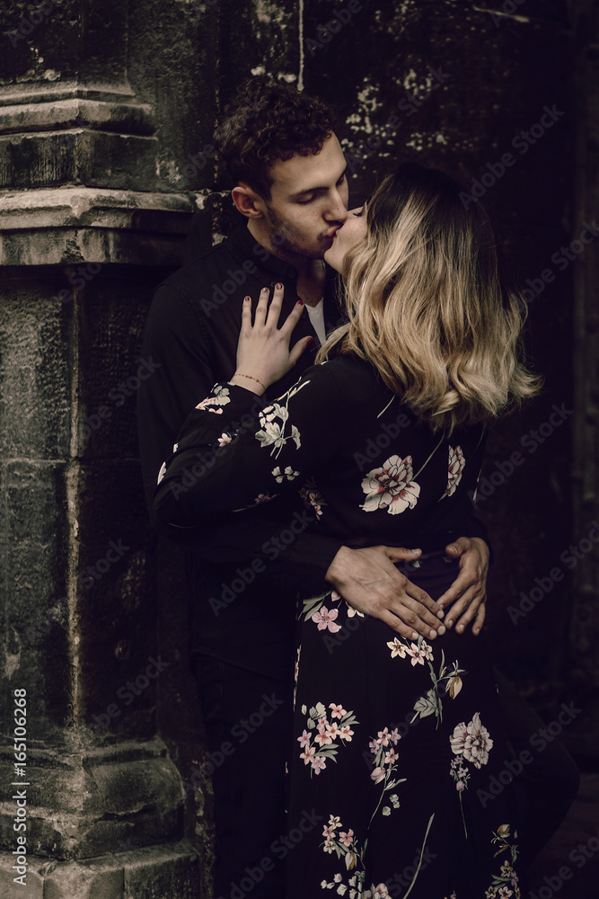stylish gypsy couple in love kissing in evening city street at old ...