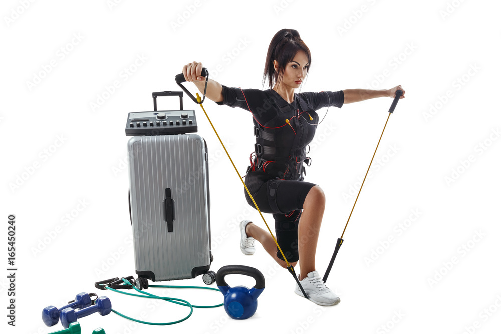 EMS fitness woman in full electrical muscular stimulation suit doing ...