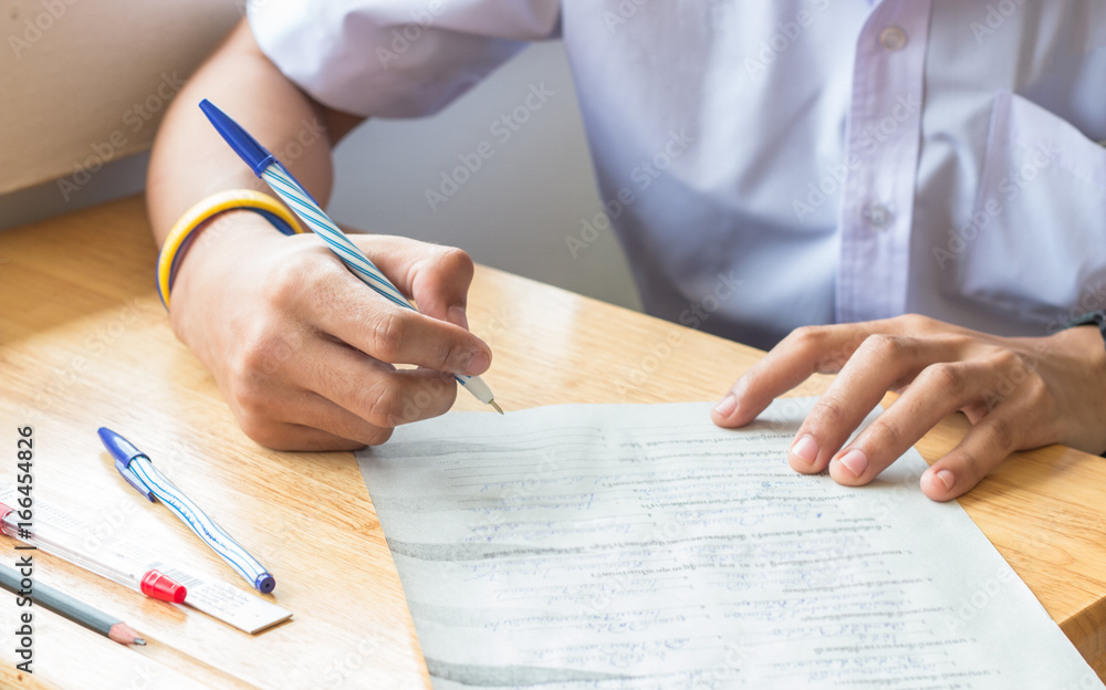 Asian School students in uniform taking examination and writing answer ...