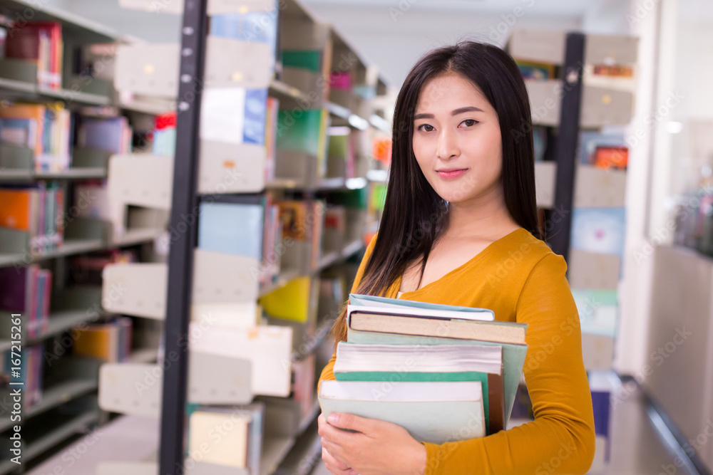 Librarian Woman in the foreground is Holding a books. Young Asian Woman ...