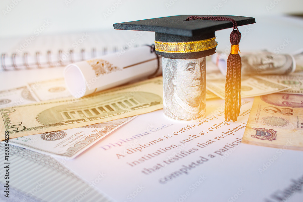 Concept of graduation black cap on roll up Dollars bill, with diploma ...