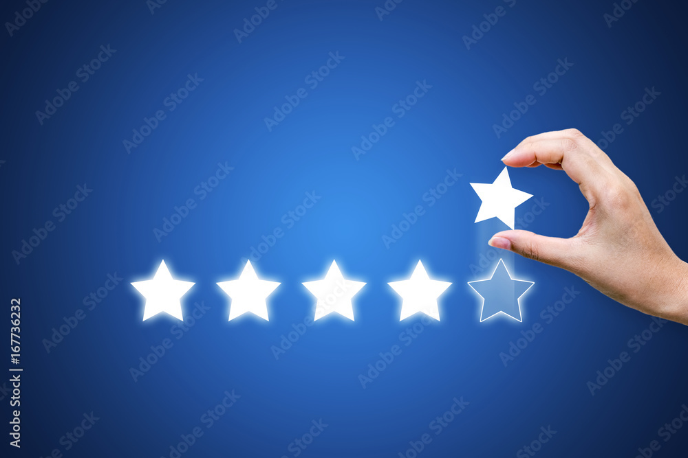 Hand putting five star symbol to increase rating of company with dark ...