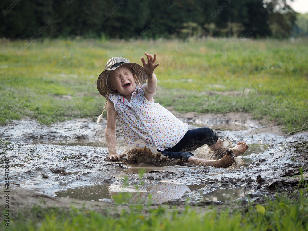 child falls in a puddle. Field. Rural road, mud Stock Photo | Adobe Stock