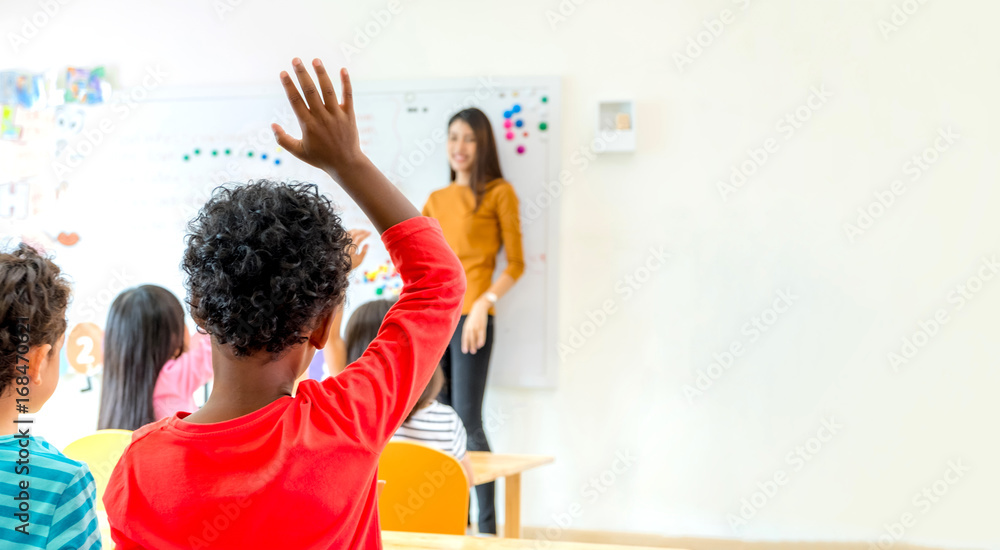 African American ethnicity kid hand up for answer question of teacher ...