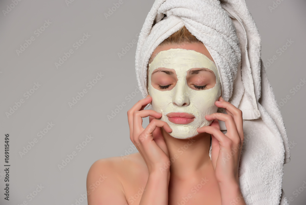 beautiful female model with facial cosmetic mask posing. Isolated on ...