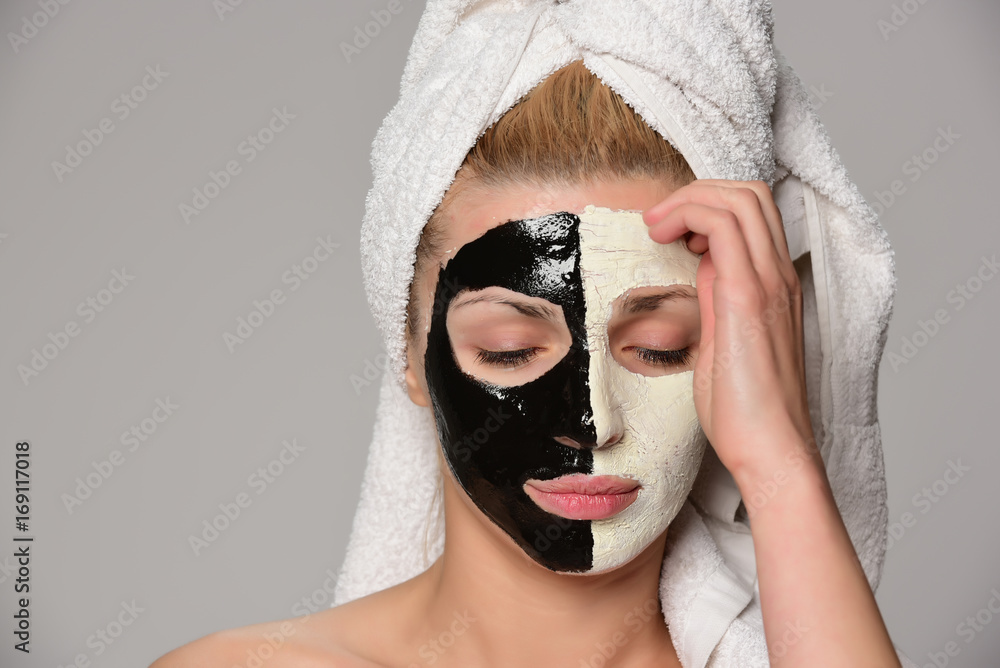 beautiful female model with black and white facial cosmetic mask posing ...