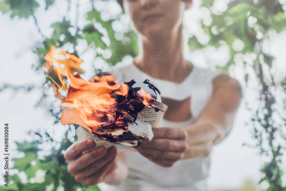 Woman writer holds book pages with flame in the hands. Concept - woman ...