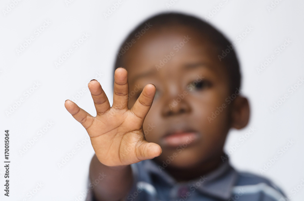 African boy holding his hand out as a STOP sign for racism and abuse ...
