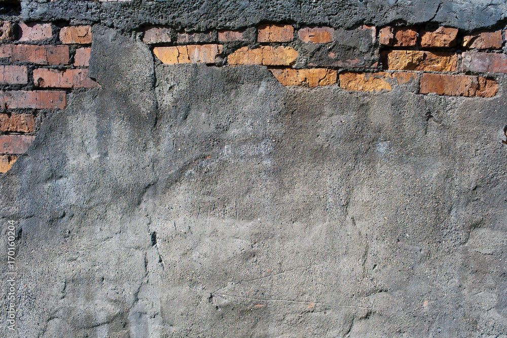 Wall from a red brick with destroyed plaster. Traces from bullets ...