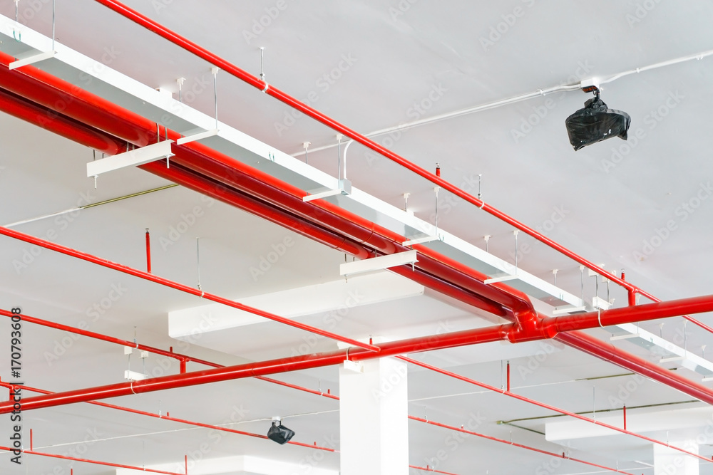Fire sprinkler system with red pipes is placed to hanging from the ...