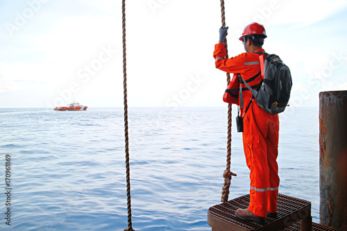 The worker prepare swing rope from platform to supply boat or passenger ...