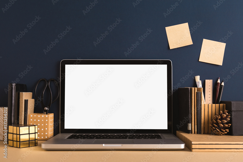 Stylish workspace with laptop computer, office supplies and Rubic's ...